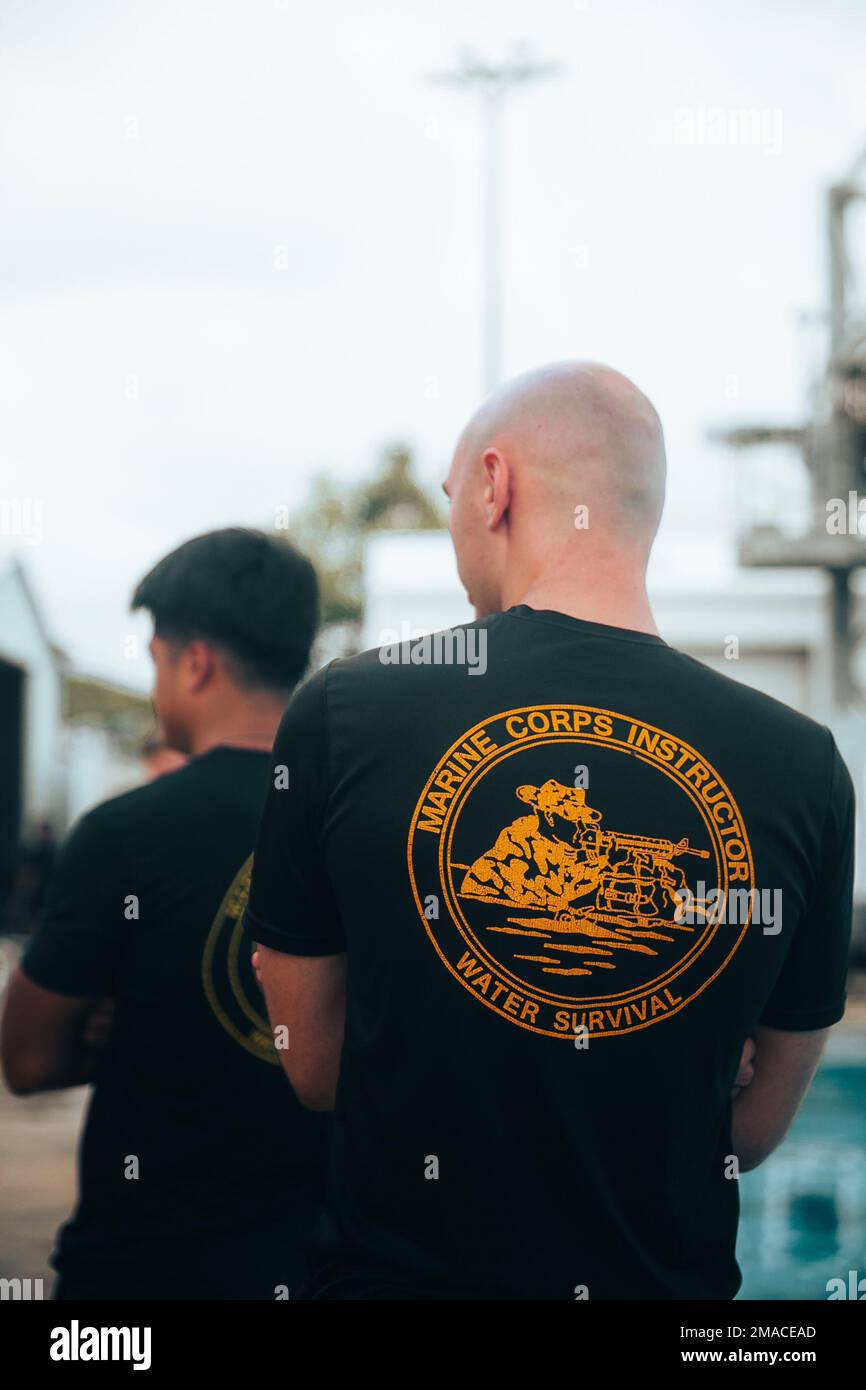 A U.S. Marine Corps Instructor of Water Survival listens to a safety ...