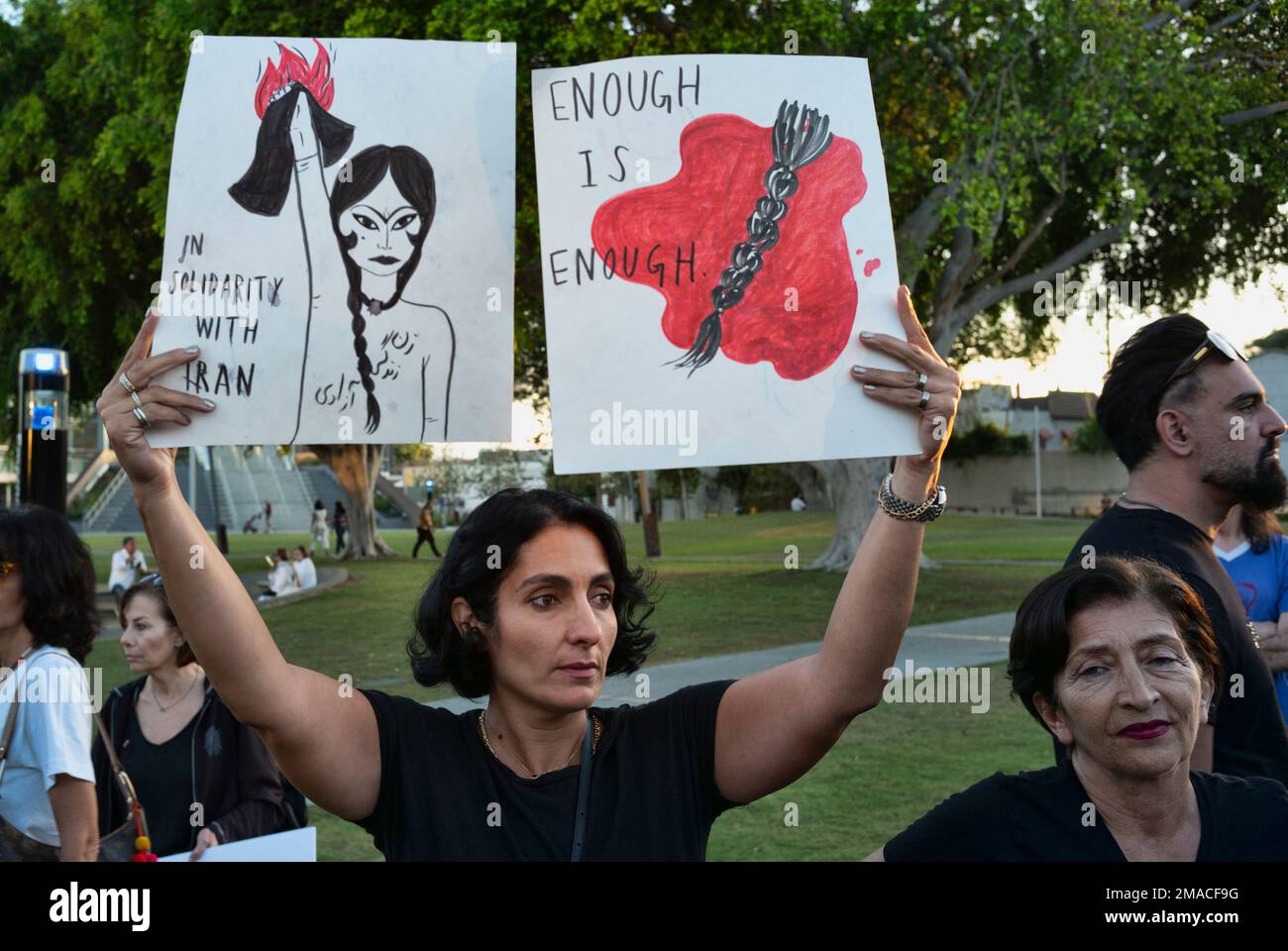Iranian American women hold signs during a vigil with the Iranian ...