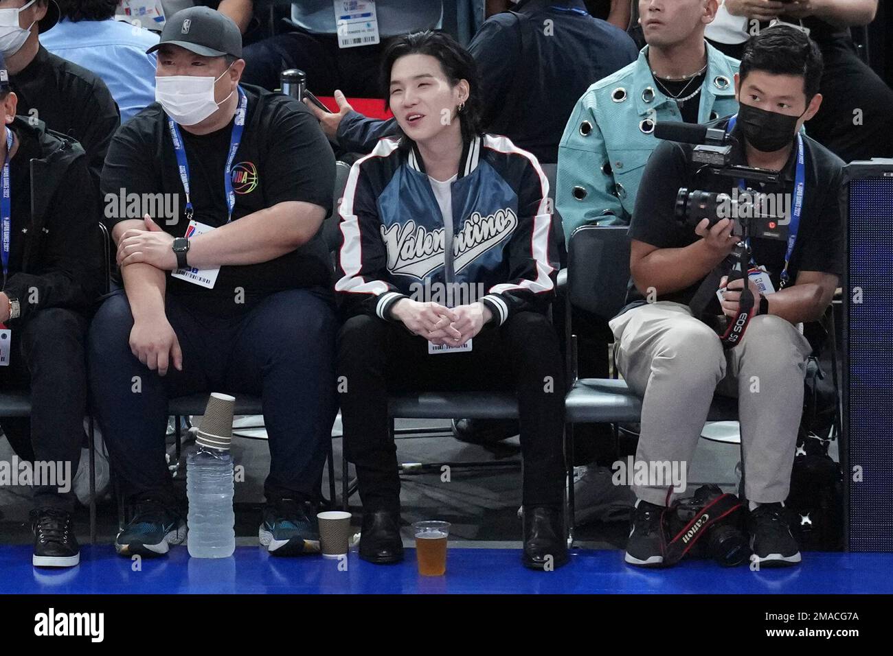 Member of K-pop supergroup BTS Suga, center, watches the preseason NBA ...