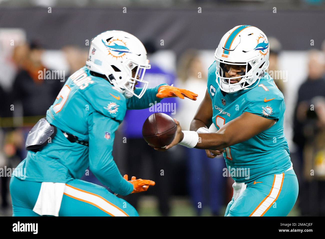 Miami Dolphins quarterback Tua Tagovailoa (1) hands off during pregame warmups before an NFL ...