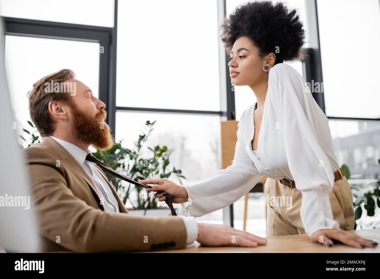 African American Woman Pulling Tie While Seducing Bearded Coworker With