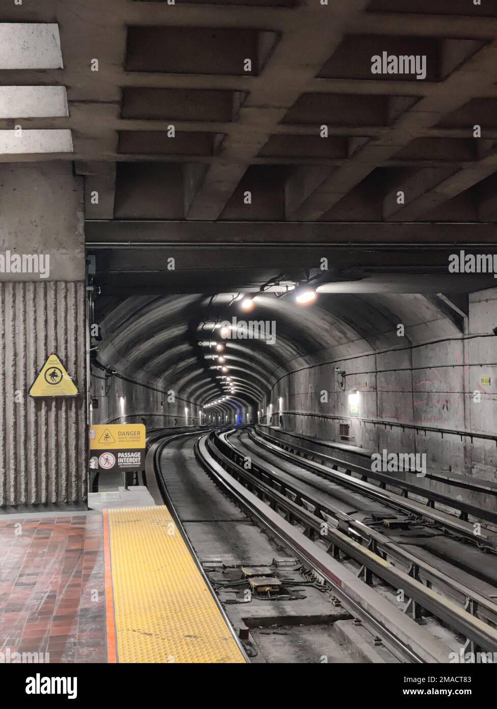 A vertical shot of the inside a train station and an empty railroad ...