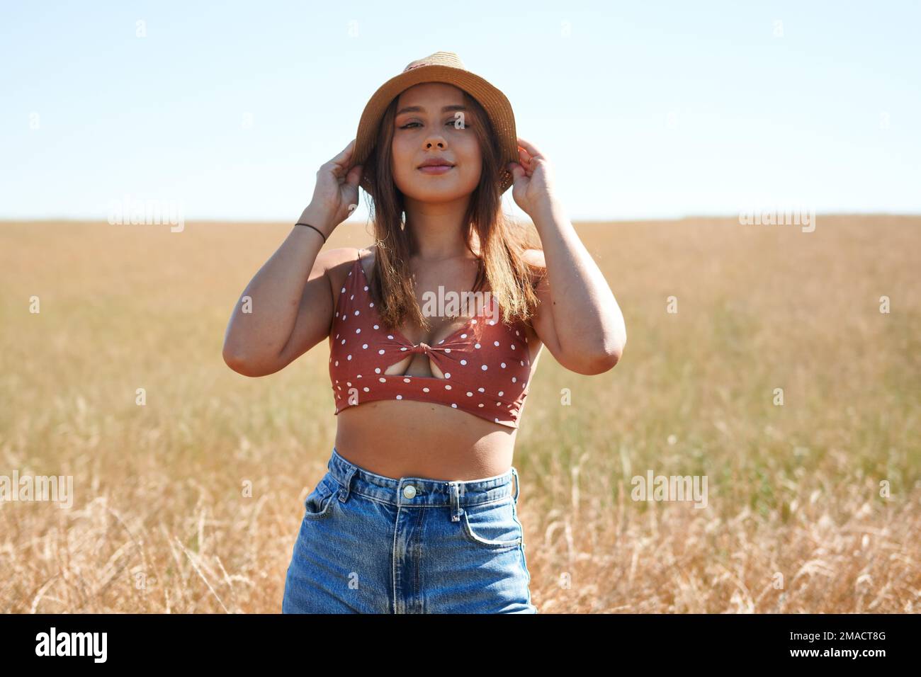 A beautiful Hispanic young woman in a field under a blue sky Stock ...