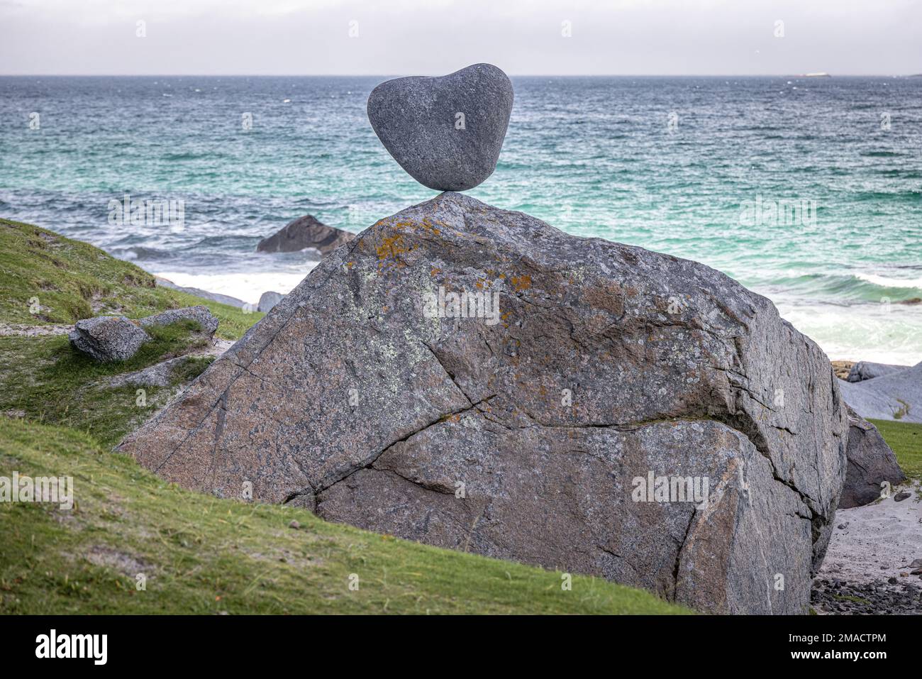 Heart-shaped rock balanced on rocks at Uttakleiv Beach, Lofoten Islands ...