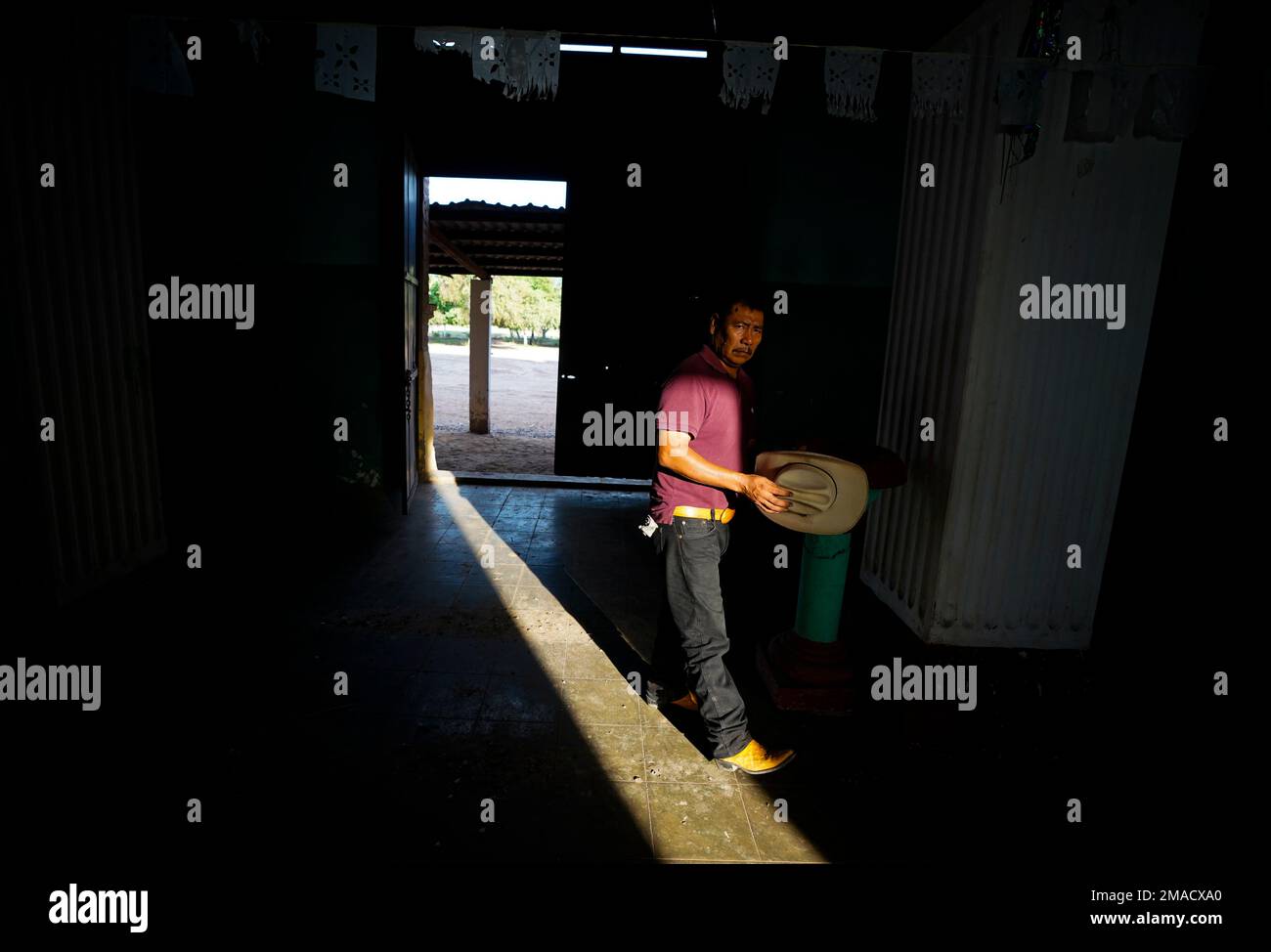A Yaqui Indigenous man removes his hat as he enters the church where ...