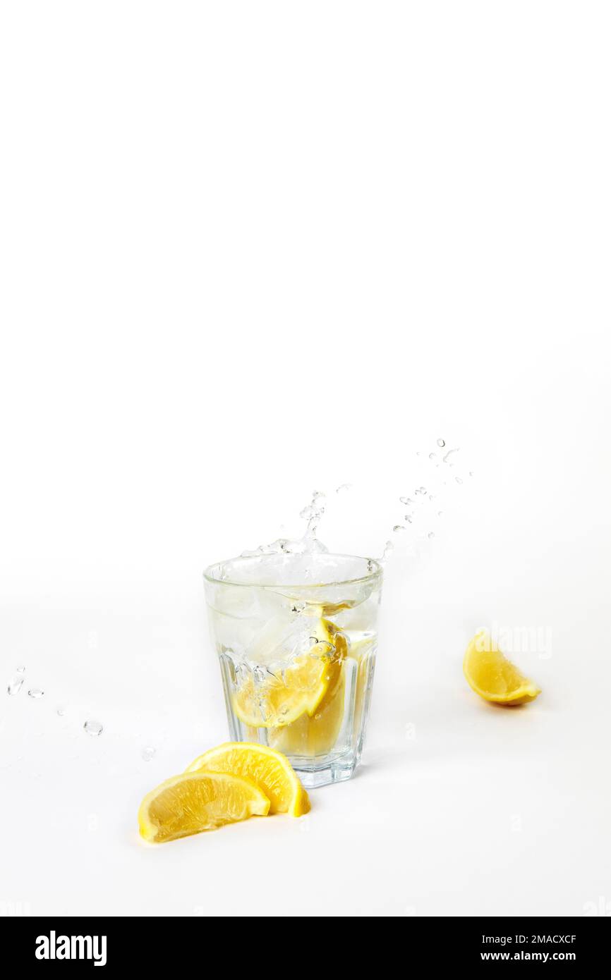 Glass of lemonade with splashing water on white background with copy ...