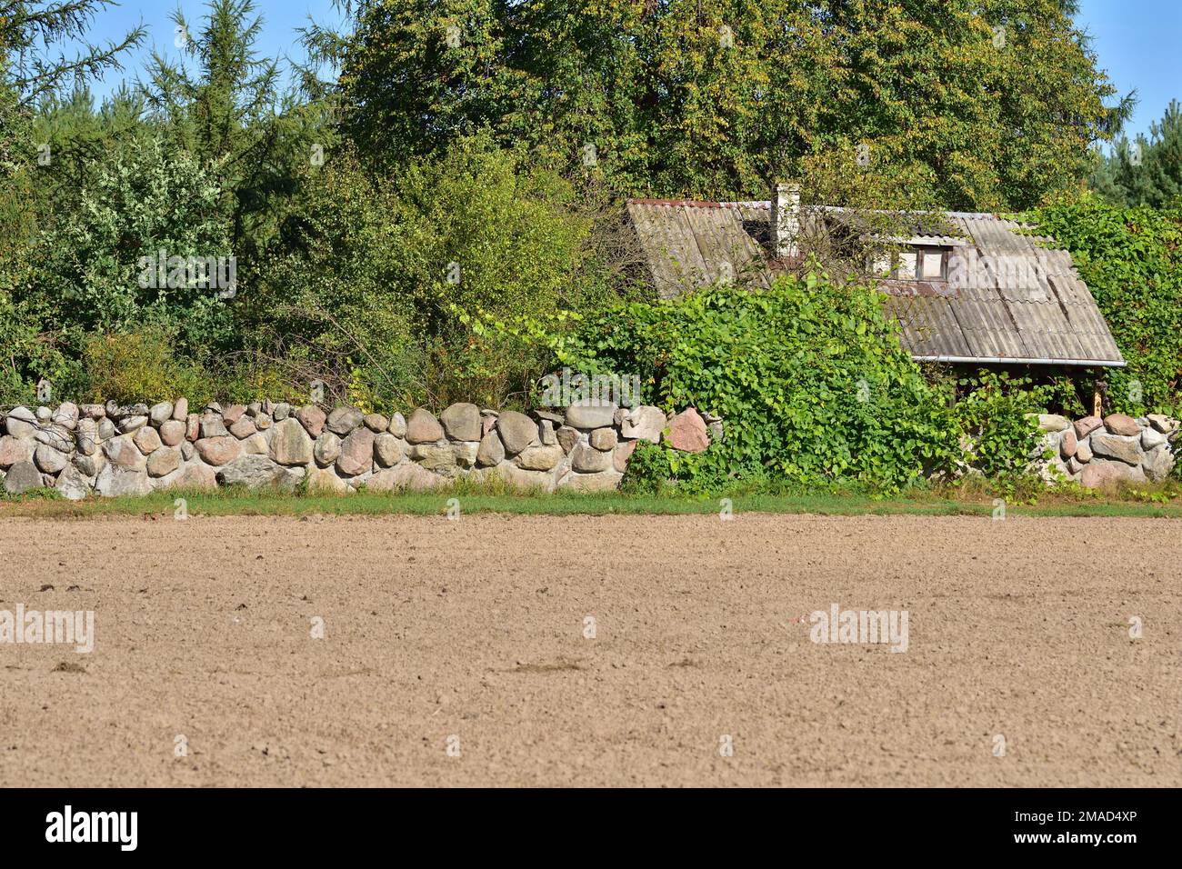 A small cottage off the beaten path surrounded by a stone wall in the ...