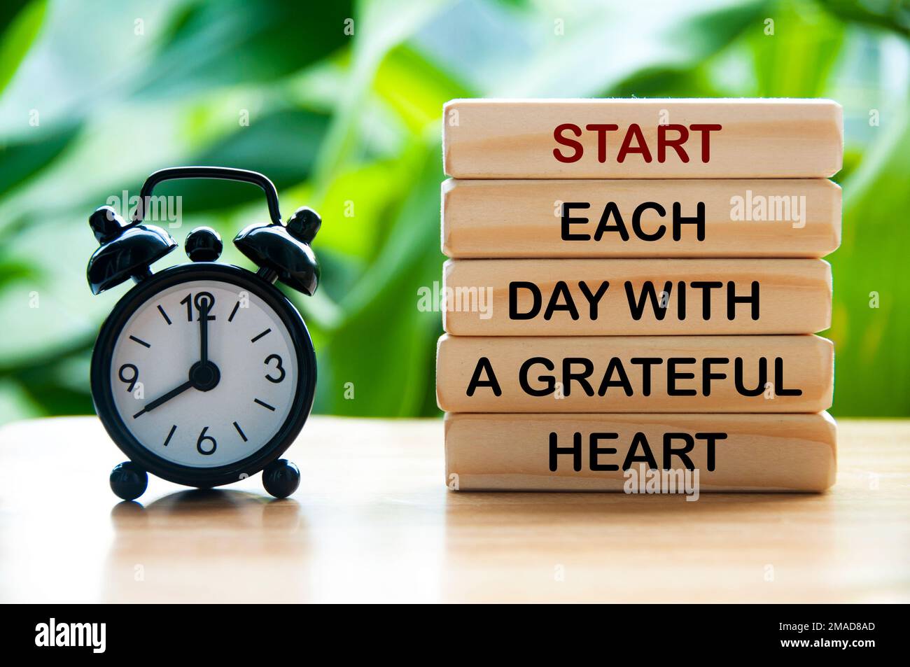 Start each day with a grateful heart text on wooden blocks with alarm ...