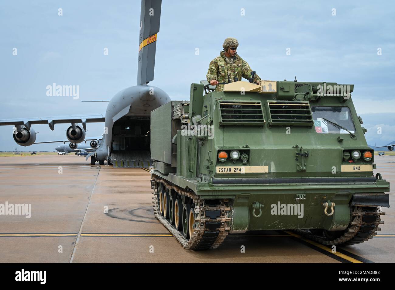 Soldiers load an M270 Multiple Launch Rocket System (MLRS) onto a C-17 ...