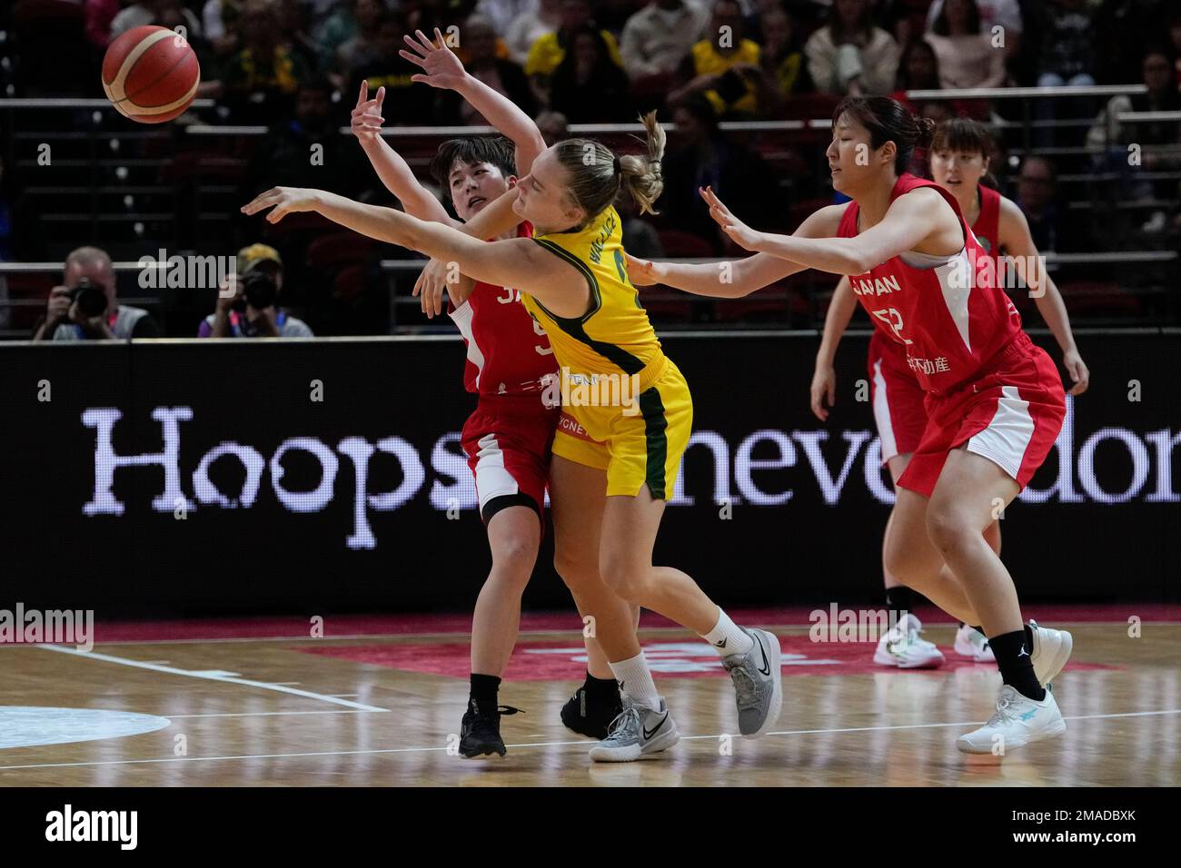 Australia's Kristy Wallace passes the ball past Japanese defenders ...