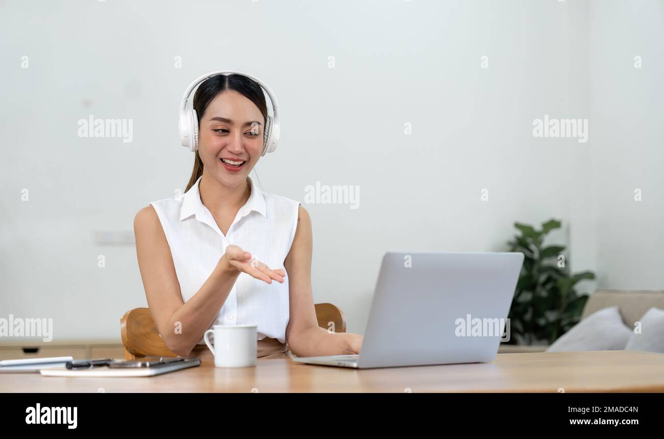 Smiling young asian woman working on laptop at home. Attractive asia ...