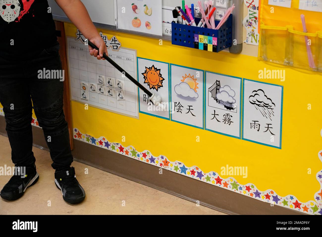 In Suzy Tom's first grade class a student points at pictures and ...
