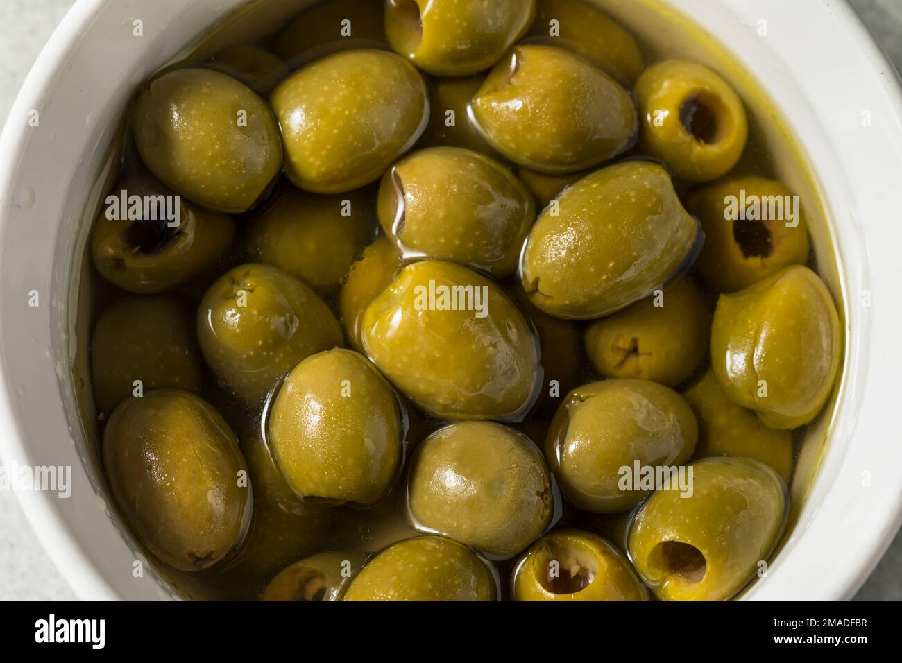 Raw Green Organic Marinated Olives in Oil Stock Photo - Alamy