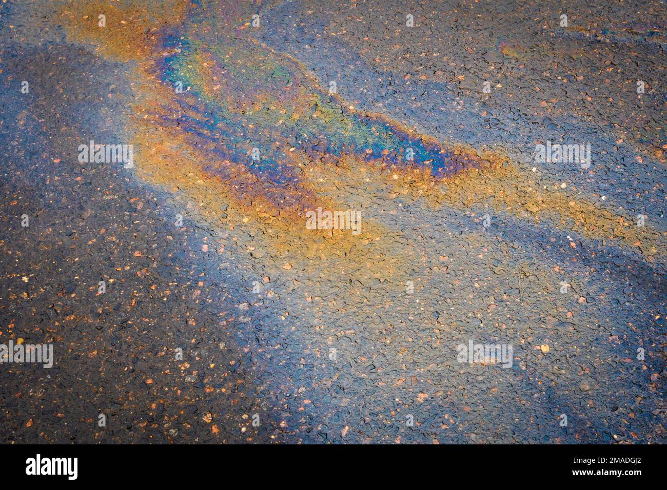 Oil stain on the asphalt, rainbow-shaped colored gasoline stains on an ...