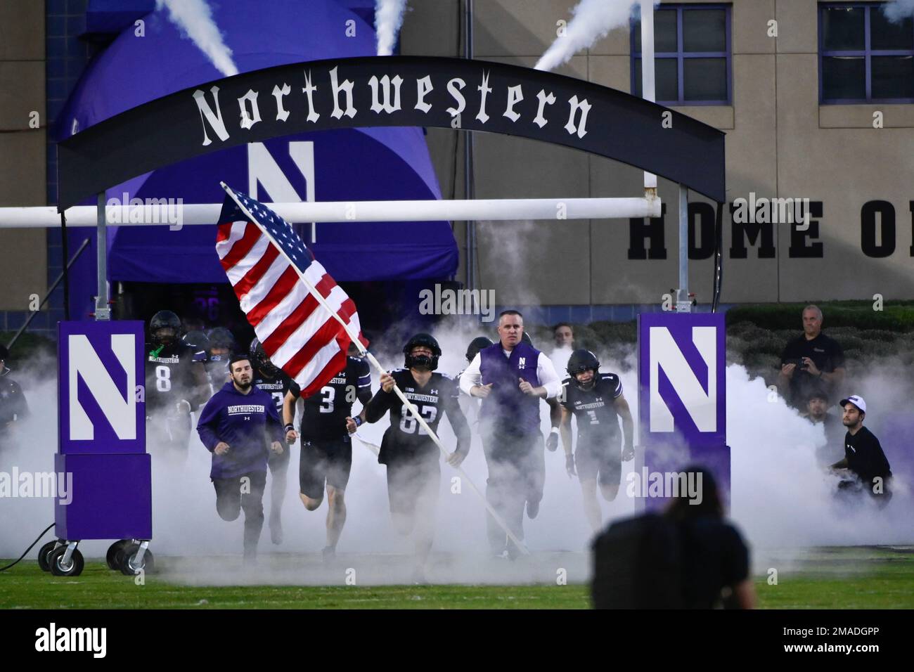 Northwestern coach Pat Fitzgerald, right, leads the team onto the field ...