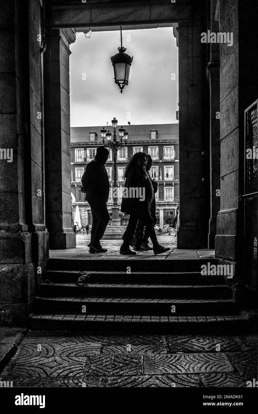 Silhouette view of a group of people walking under the arches in Plaza ...