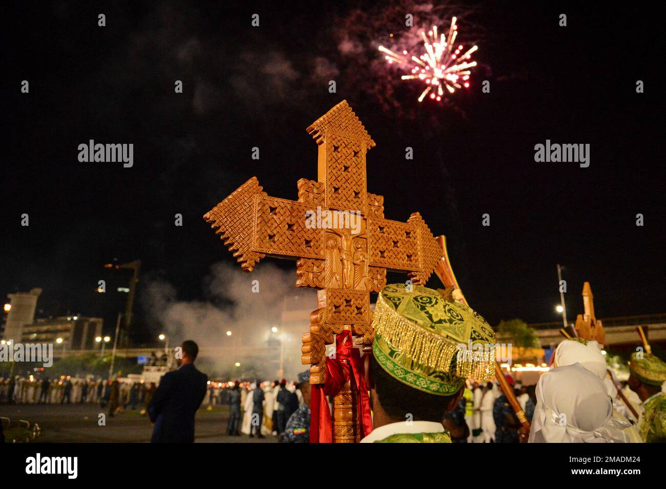 An Ethiopian Orthodox Christian holds a crucifix as fireworks explode ...