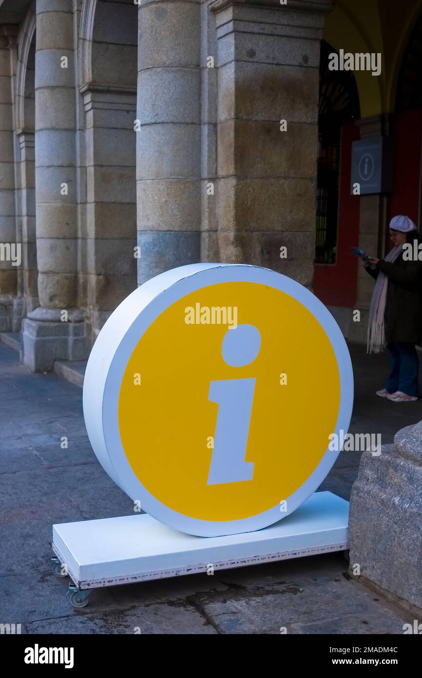 Woman behind the yellow sign for I for tourist information in Plaza ...