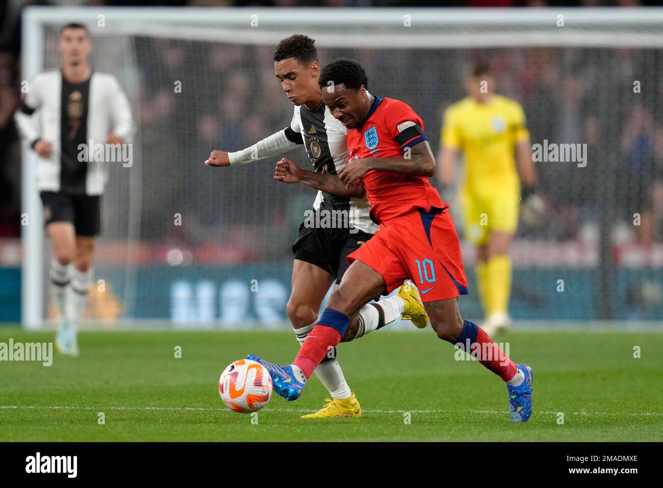 England's Raheem Sterling, right, challenges for the ball with Germany ...
