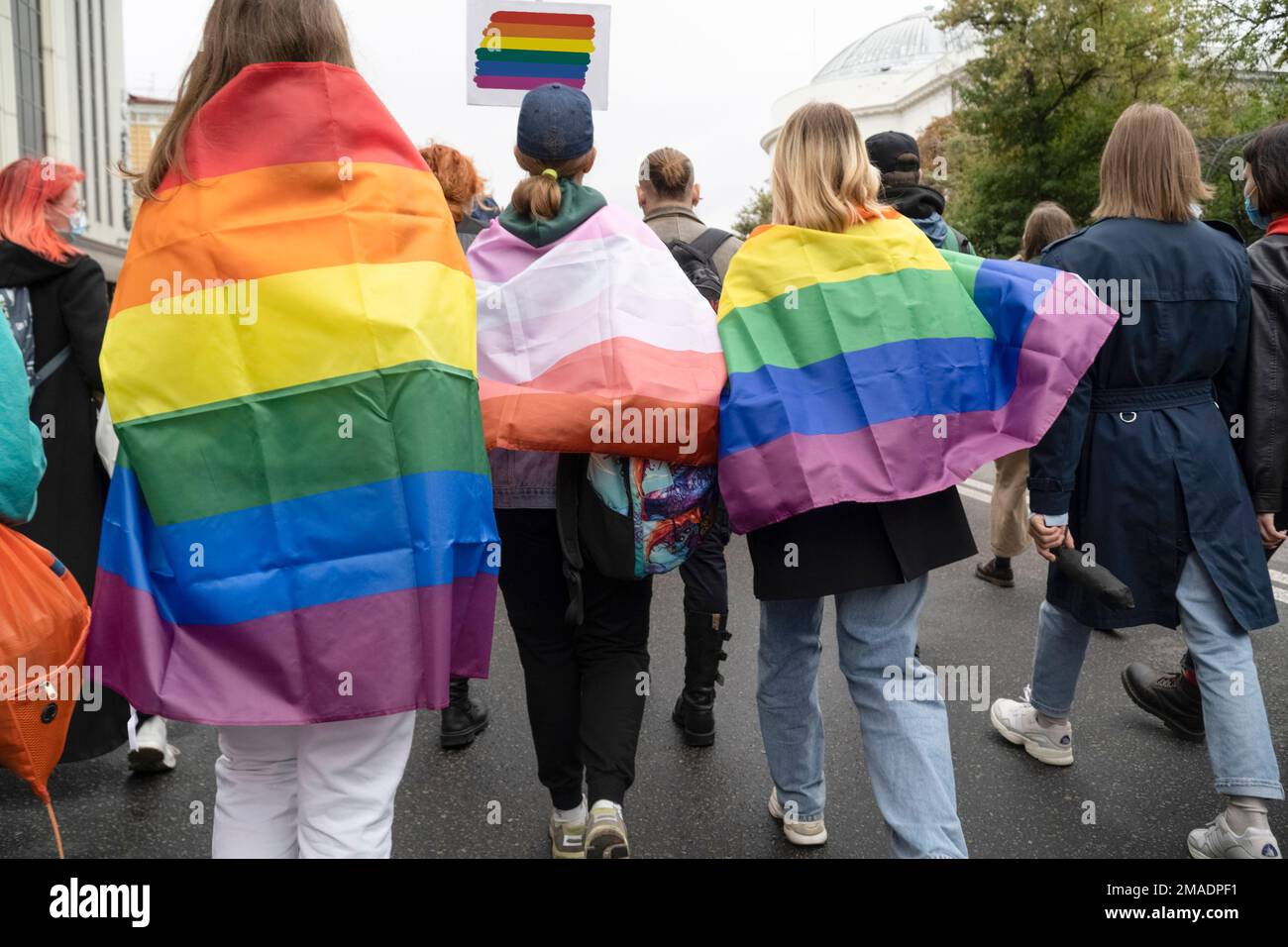 People with LGBT flags are marching. Pride procession along the street ...