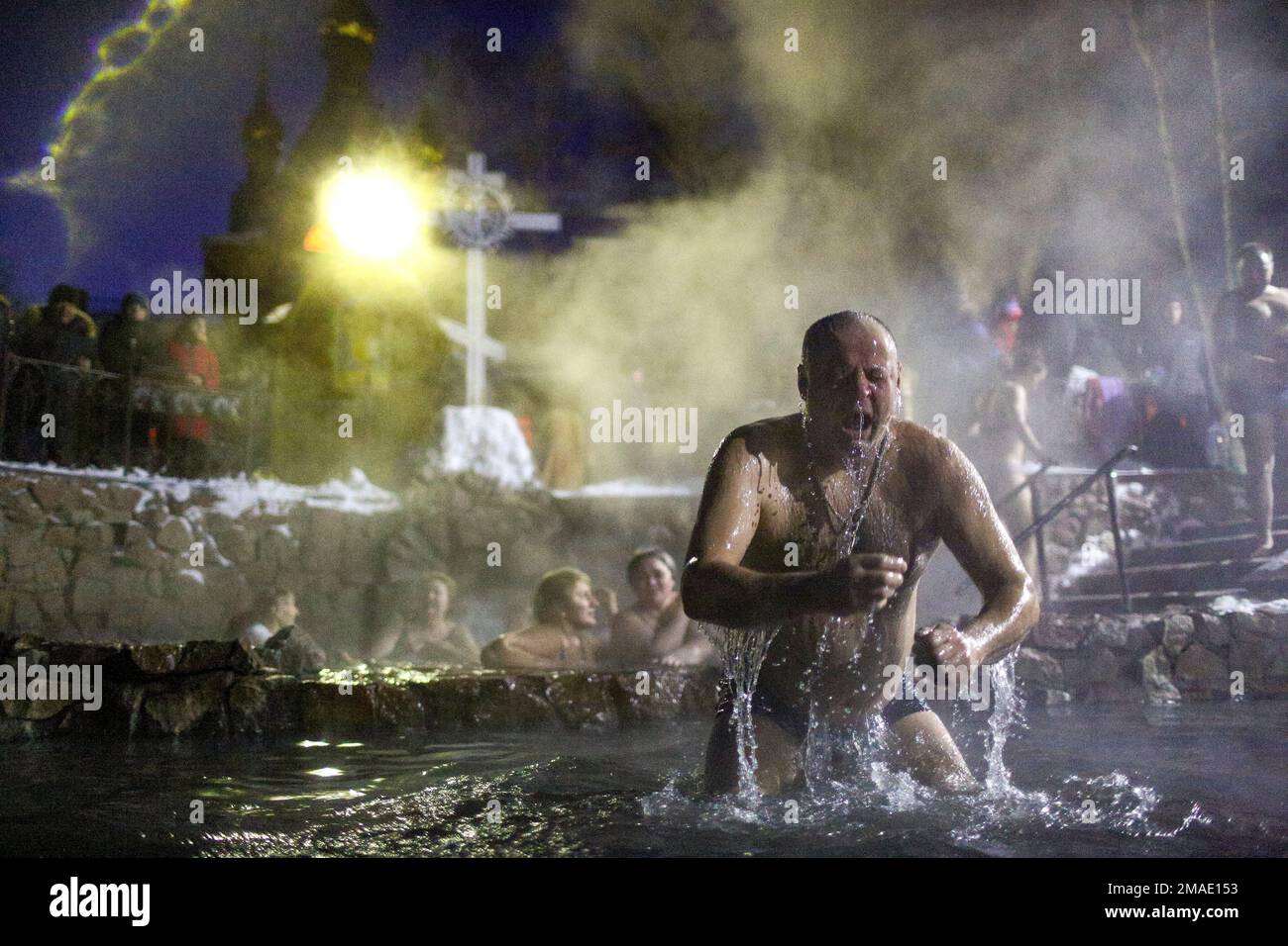 A man bathes in water during a traditional Epiphany celebration as the ...