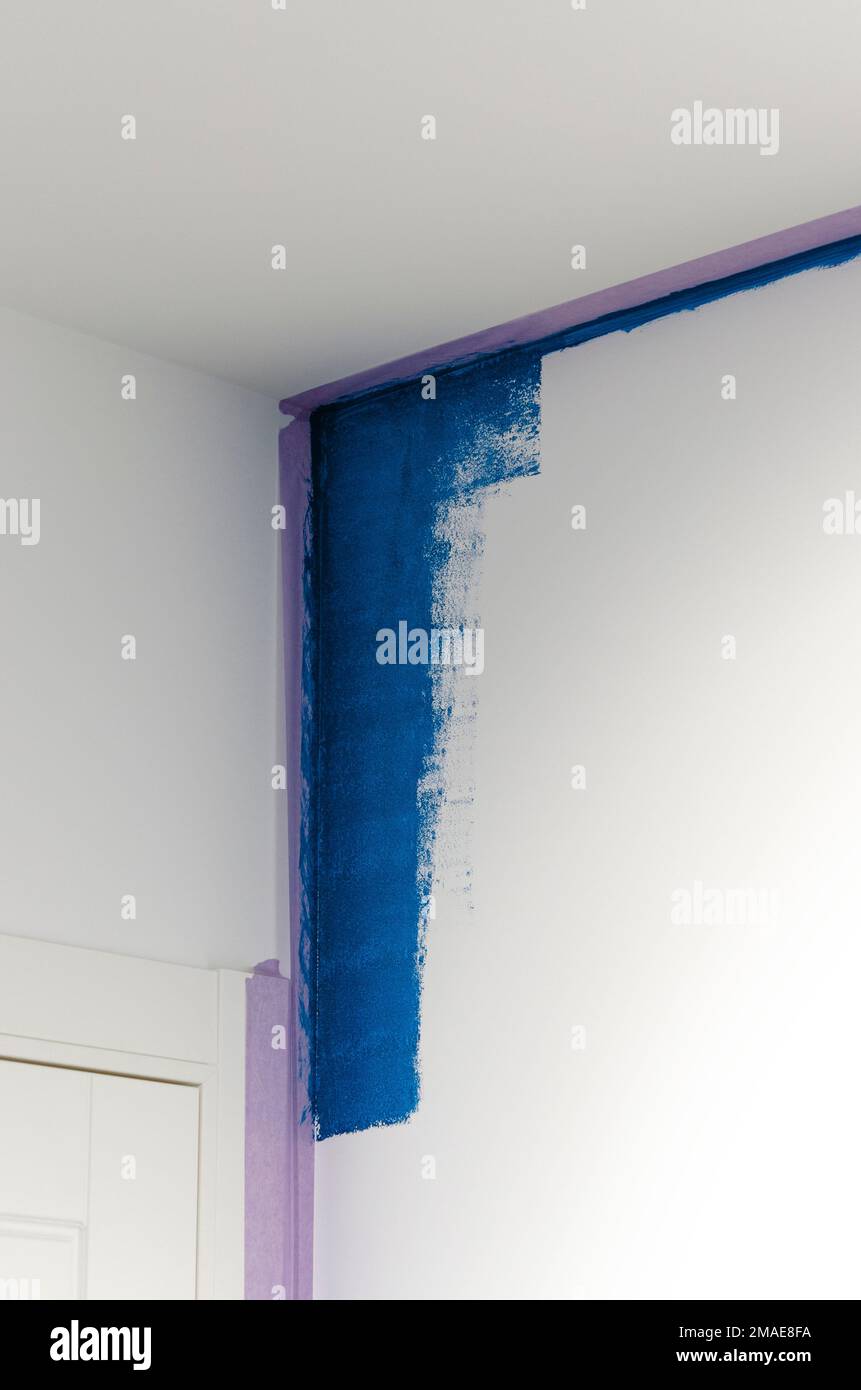 Repair. White wall in blue staining process Stock Photo - Alamy