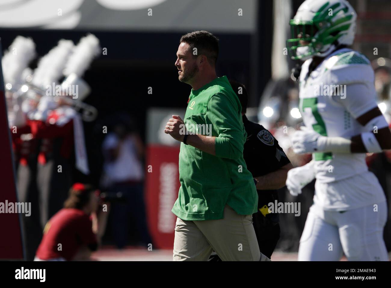 Oregon head coach Dan Lanning, left, runs onto the field with his team ...