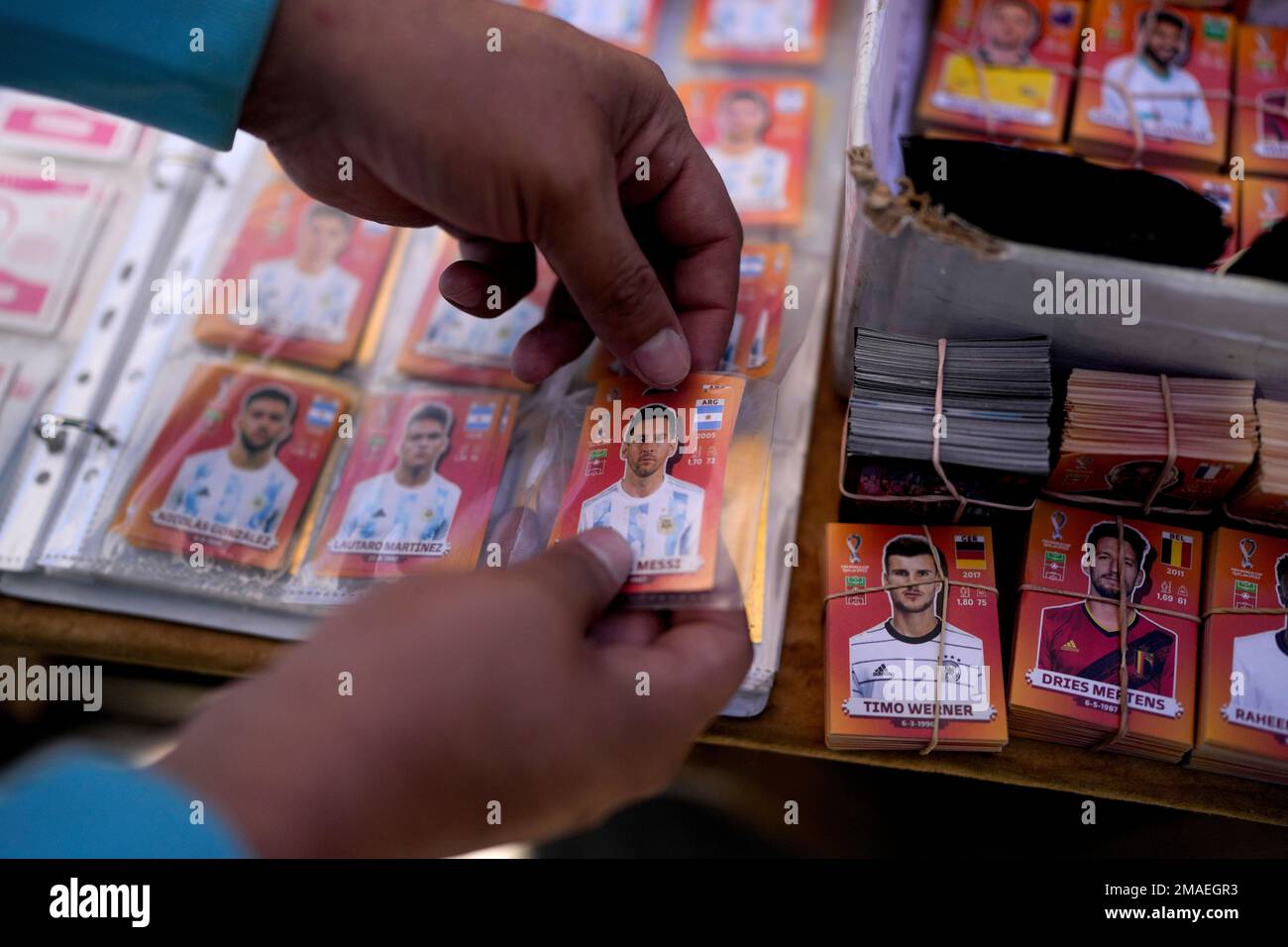 A street seller places a Panini collection stickers of Lionel Messi in ...