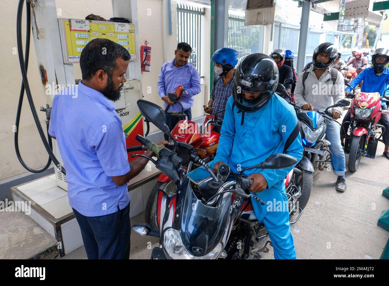 An employee of a fuel station fills petrol in a vehicle in the Paribagh area in Dhaka ...