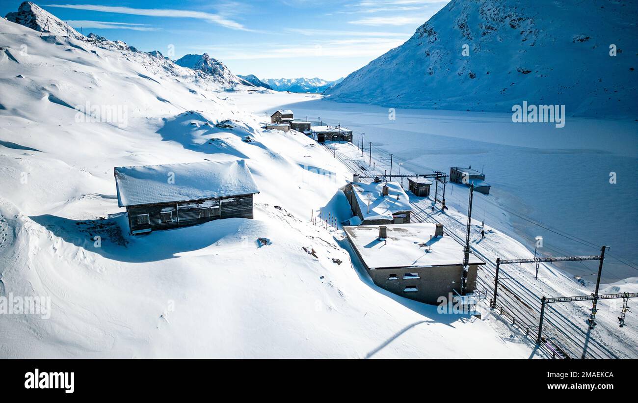 Aerial view of wooden cabin hut and train station and tracks covered in ...