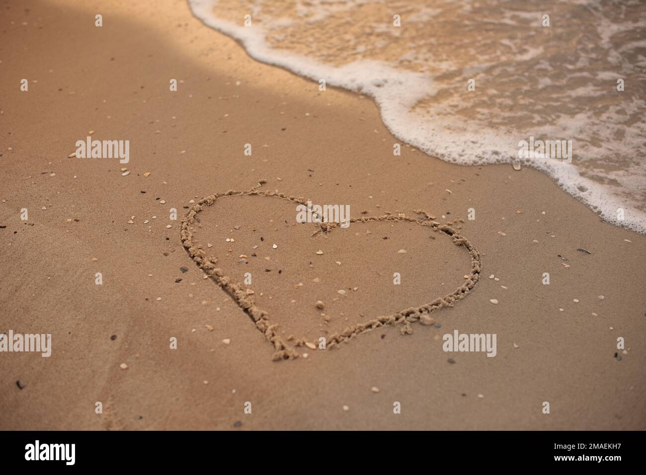 Heart drawing on sea sand,natural background Stock Photo - Alamy