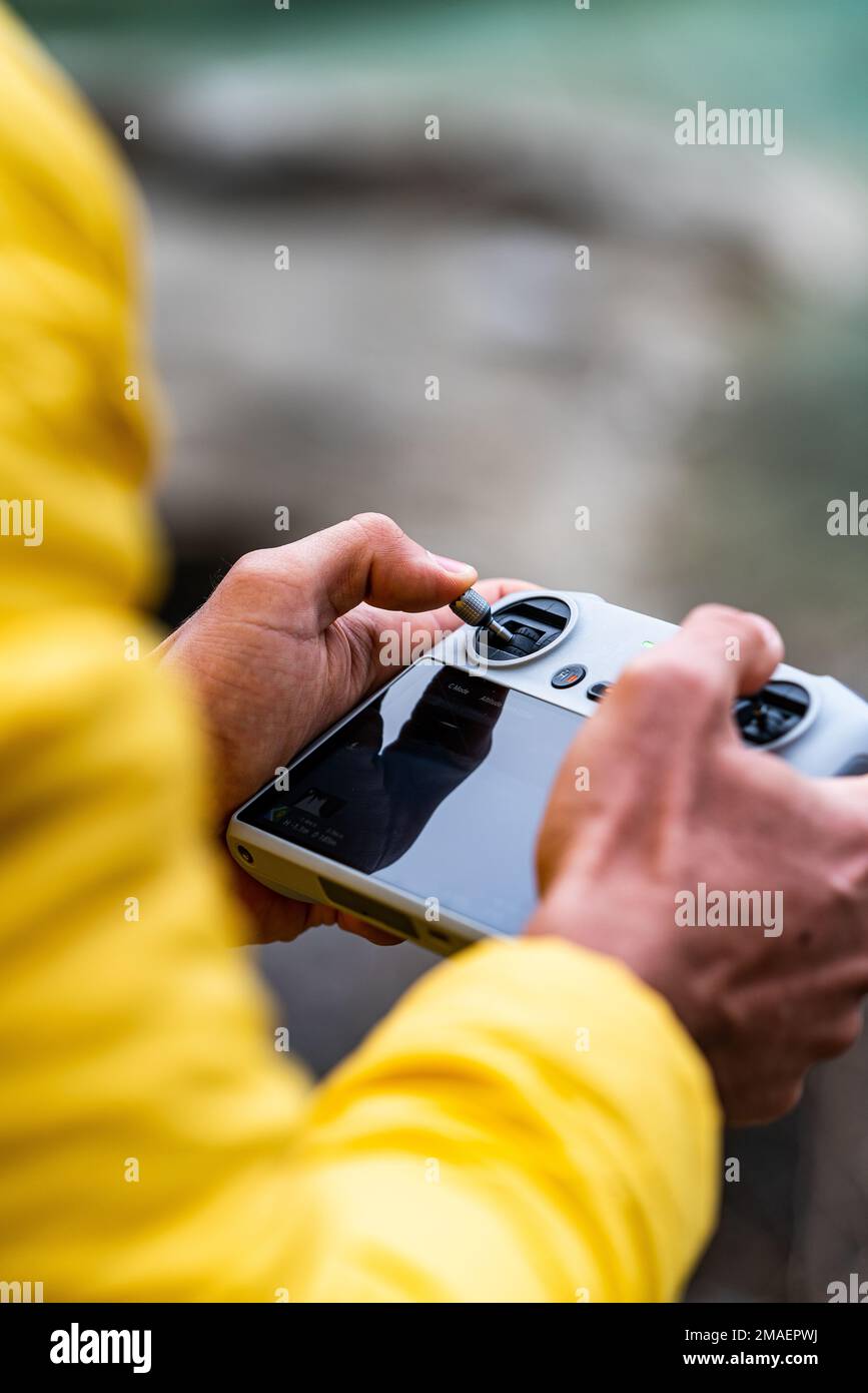 Detail of hands of caucasian man operating remote drone controller ...