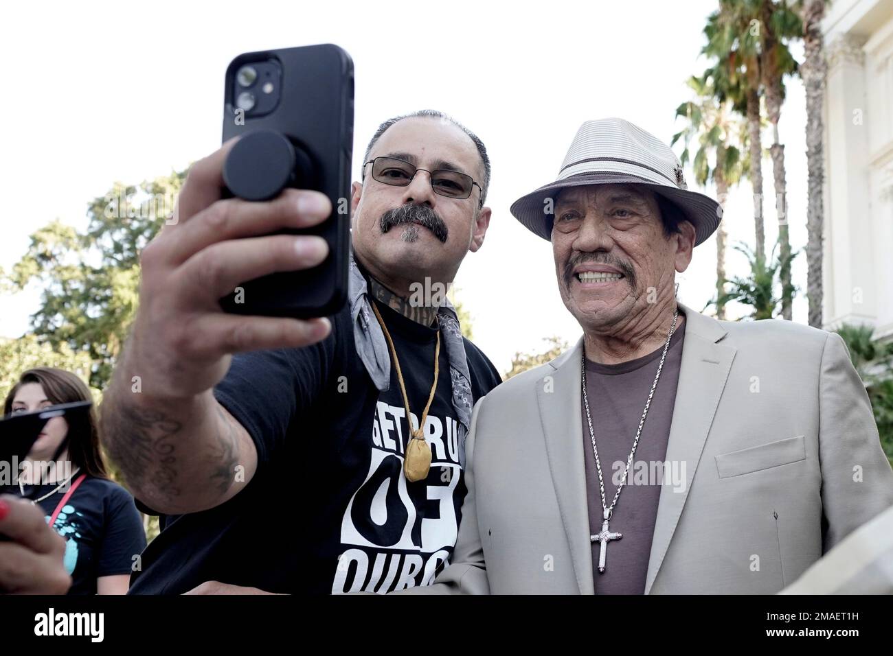 Albert Roman Jr., left, takes a photo with actor Danny Trejo who spoke ...