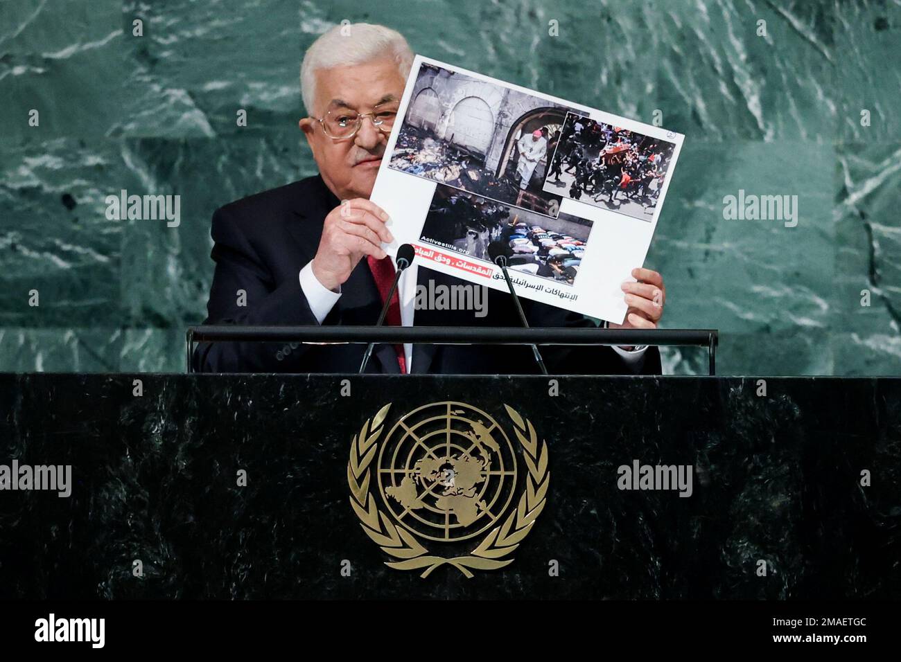 Palestinian President Mahmoud Abbas holds up photographs while ...