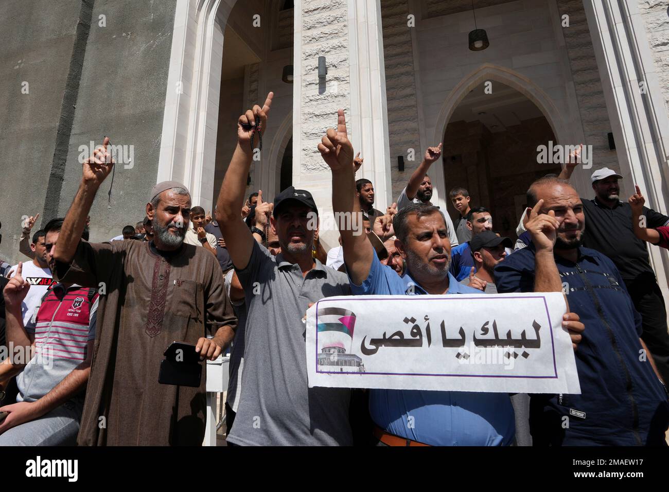 Palestinians raise their hands up while chant slogans during a rally ...
