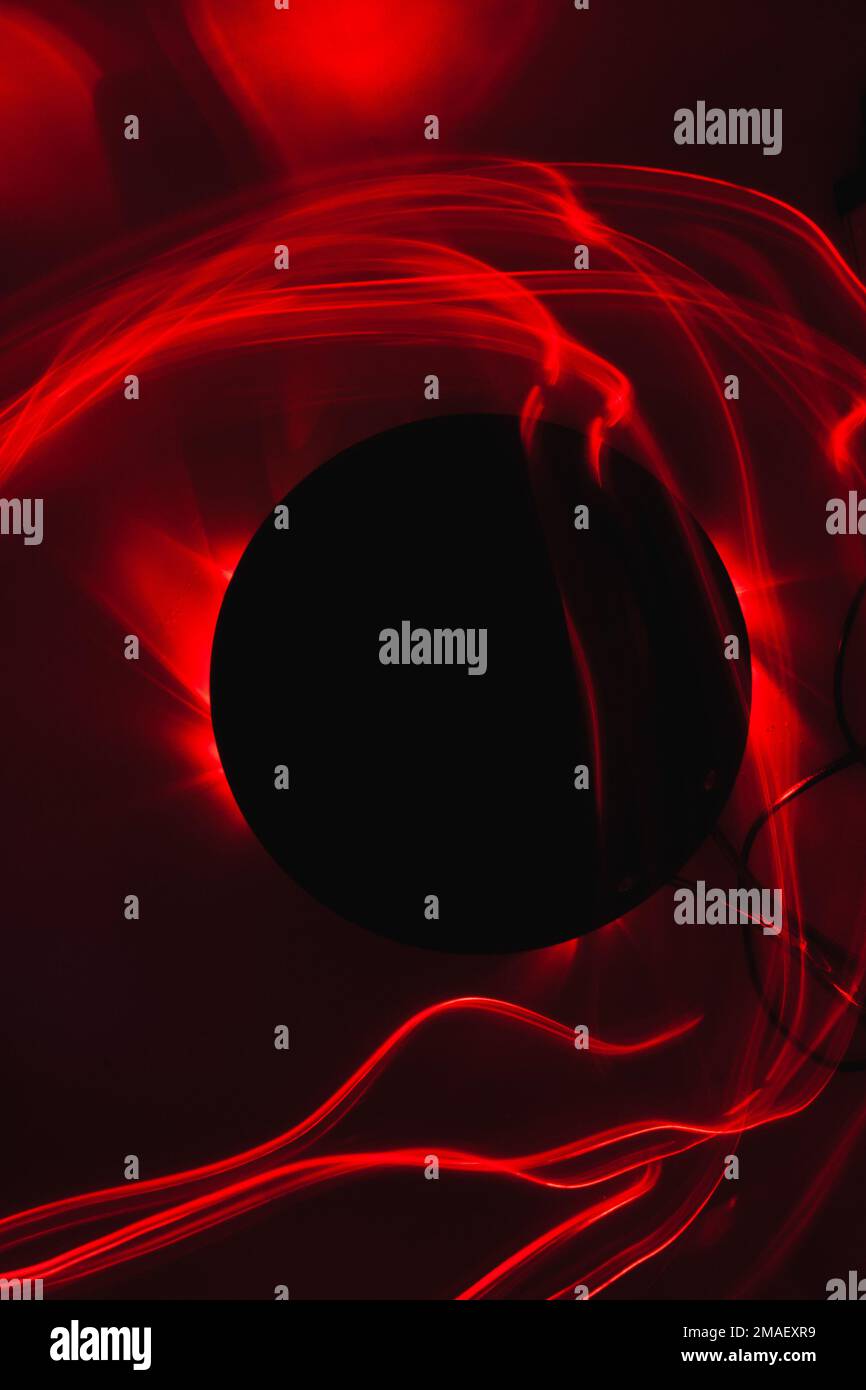 black frying pan in the dark under which red lights are lit, which emit ...