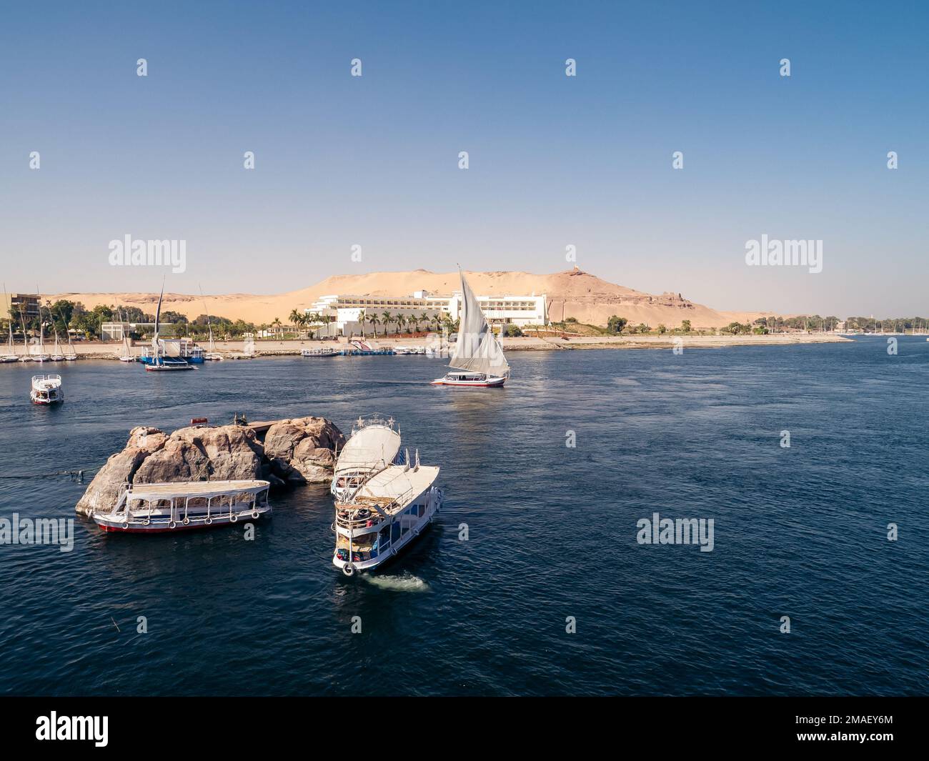 Felucca boat sailing on the Nile river with sand dunes in background in ...