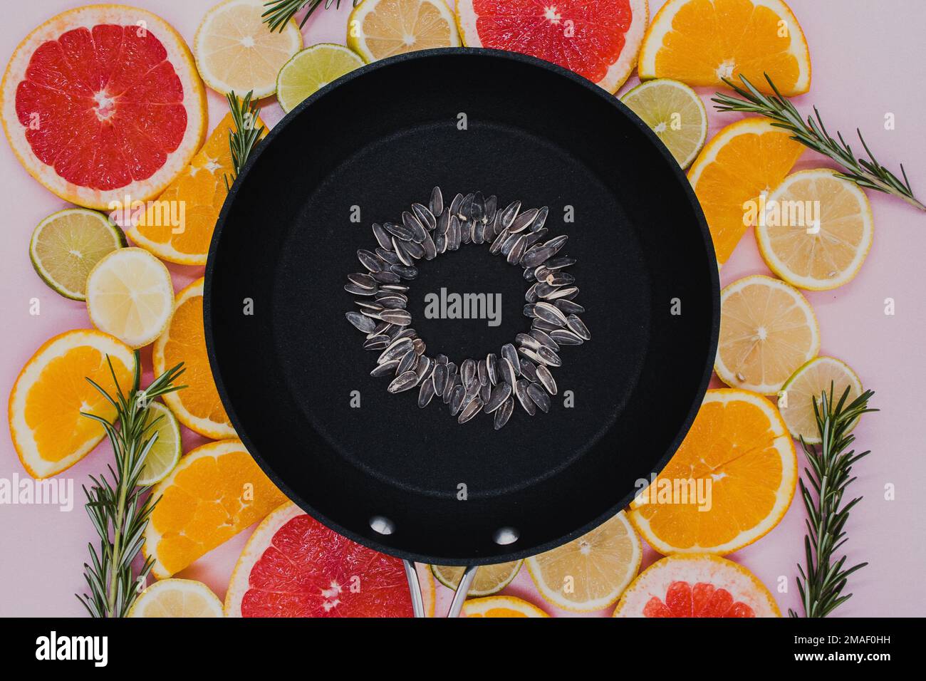 black frying pan with sunflower seeds, from which a sunflower flower is ...