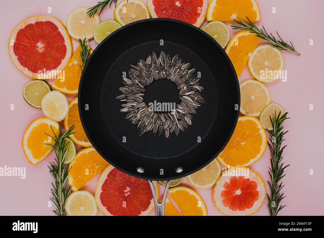 black frying pan with sunflower seeds, from which a sunflower flower is ...