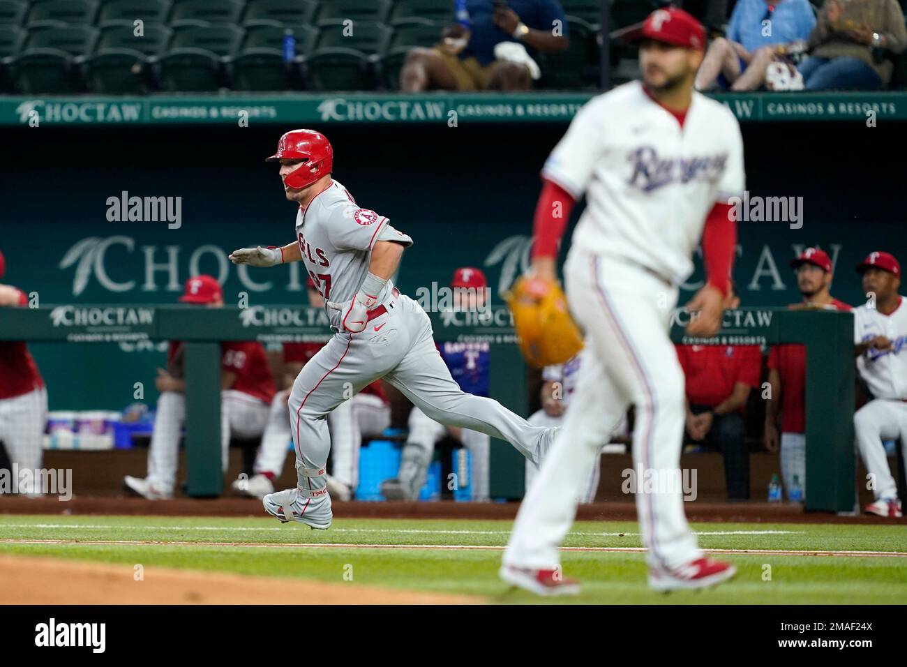 Los Angeles Angels' Mike Trout, left, sprints down the first base line ...
