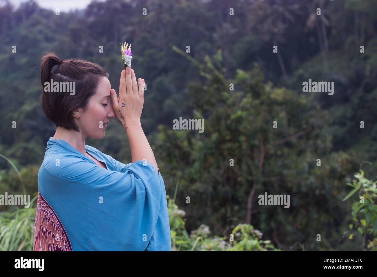 A beautiful woman performing a Hindu ritual while immersing in nature ...
