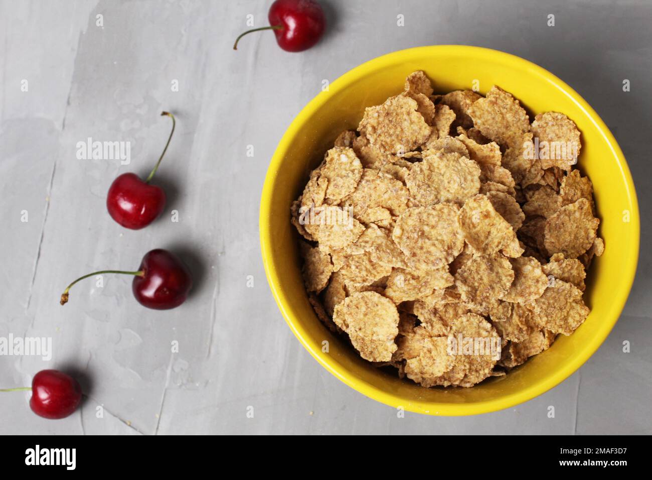 healthy breakfast oatmeal corn flakes in a bowl of yellow with cherry ...