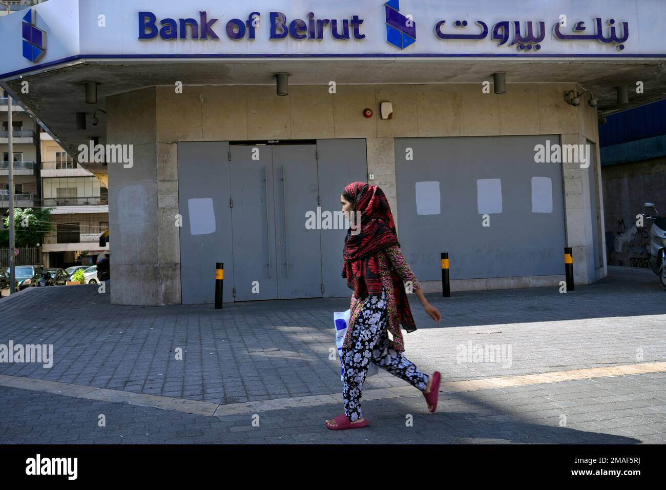 The facade of a closed Bank of Beirut branch is covered with metal ...