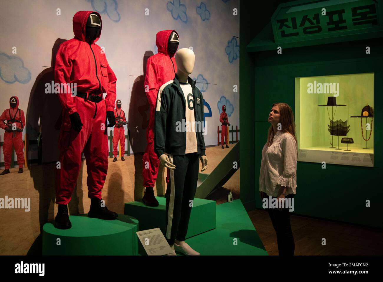 A museum visitor is seen looking at props used for the TV series 'Squid ...
