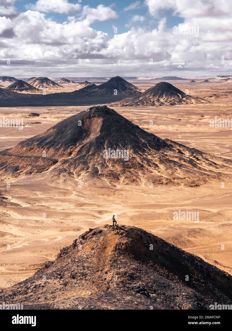 Woman standing on top of a volcanic hill looking at landscape in Black ...