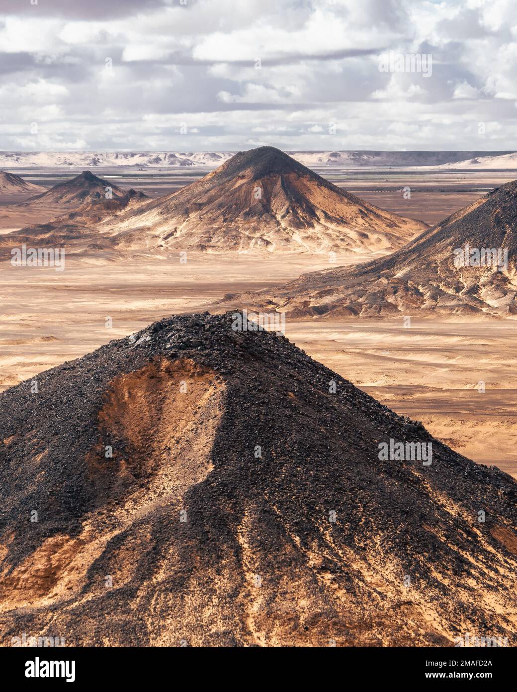 Volcanic hills and landscape in Black Desert, Egypt on a cloudy day ...
