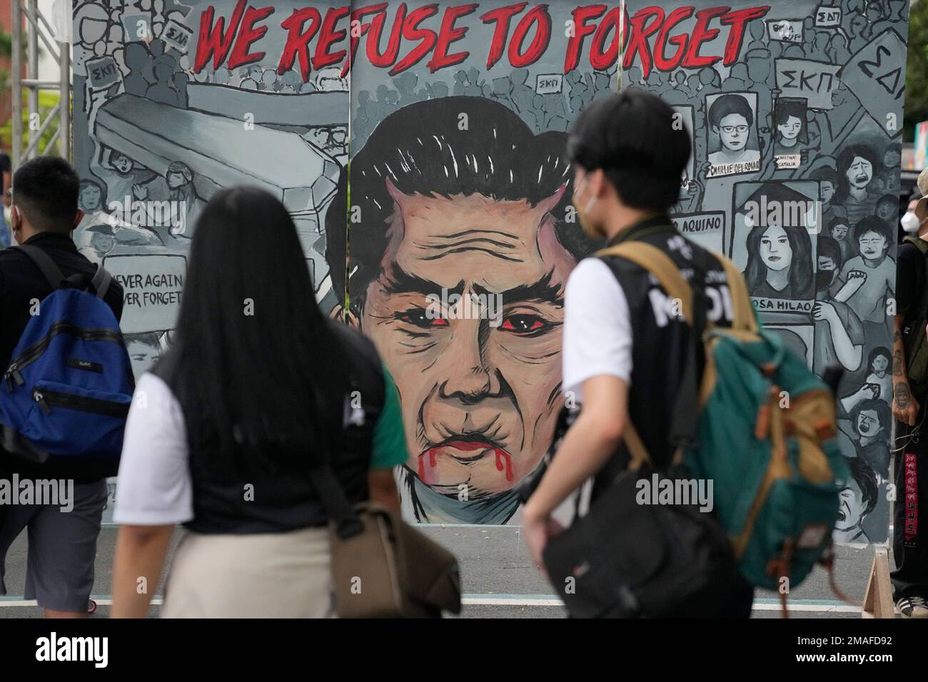People walk past a banner with the face the late dictator Ferdinand ...