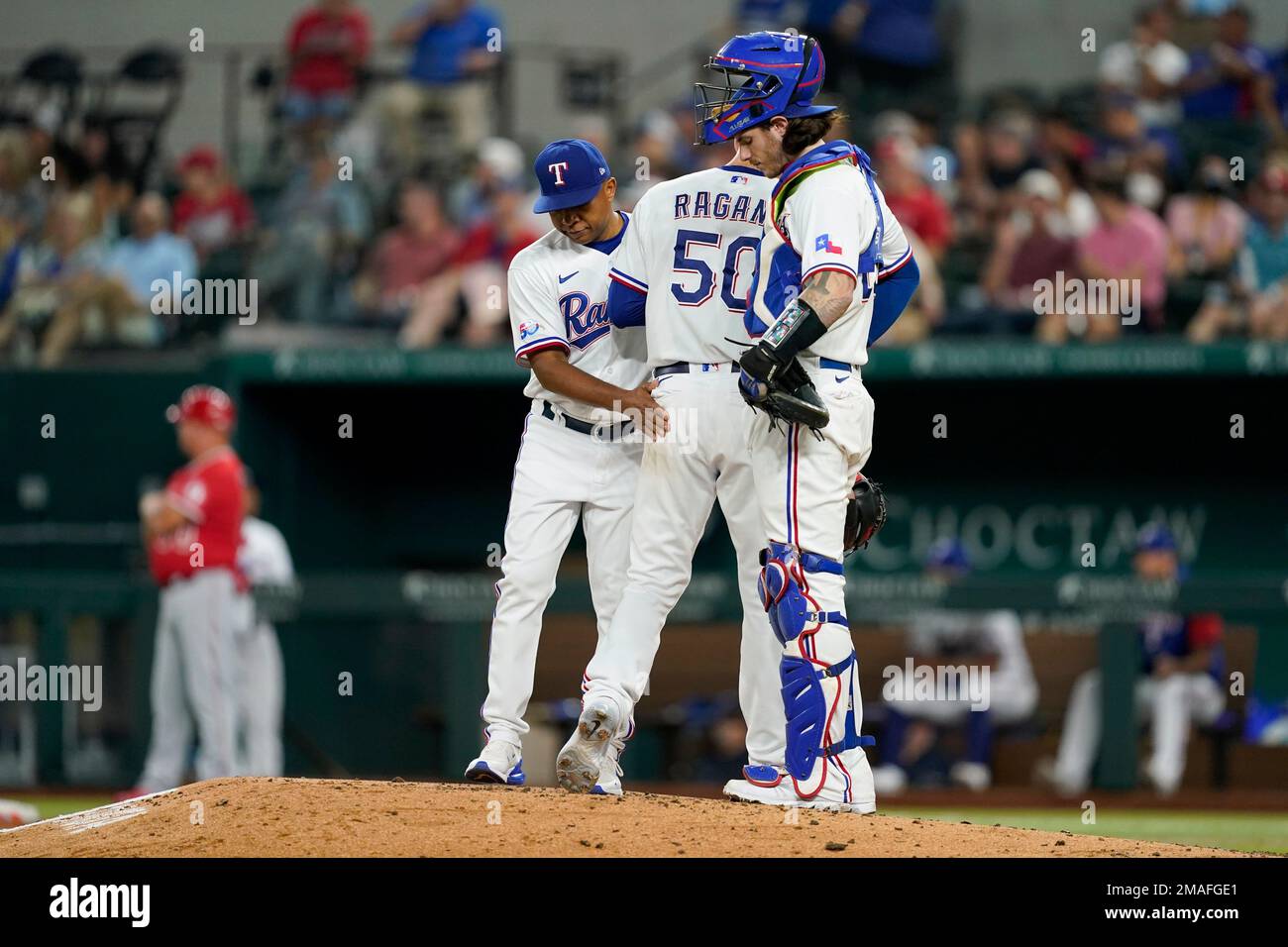 Texas Rangers interim manager Tony Beasley, left, takes the ball from ...