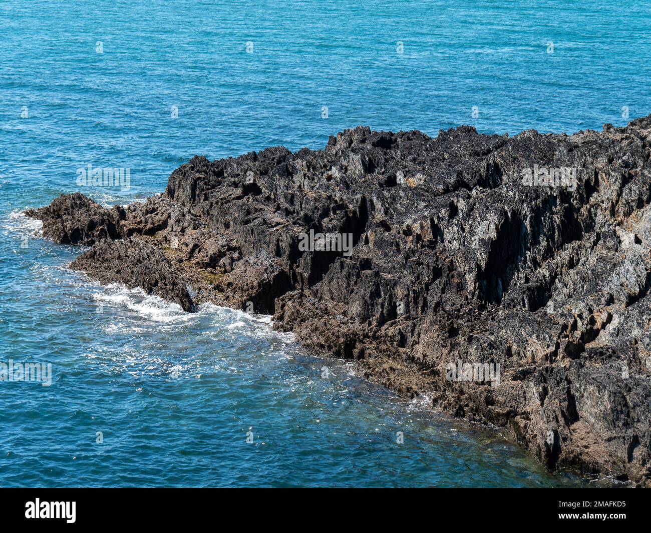 A huge stone rock among the blue sea waters. Sea landscape, rock beside ...