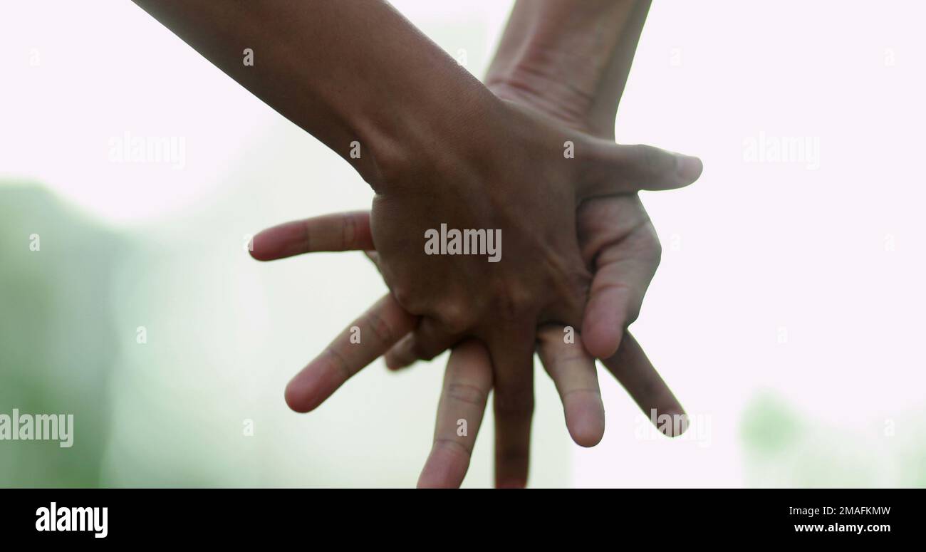 Close-up of two people joining hands together in relationship and ...